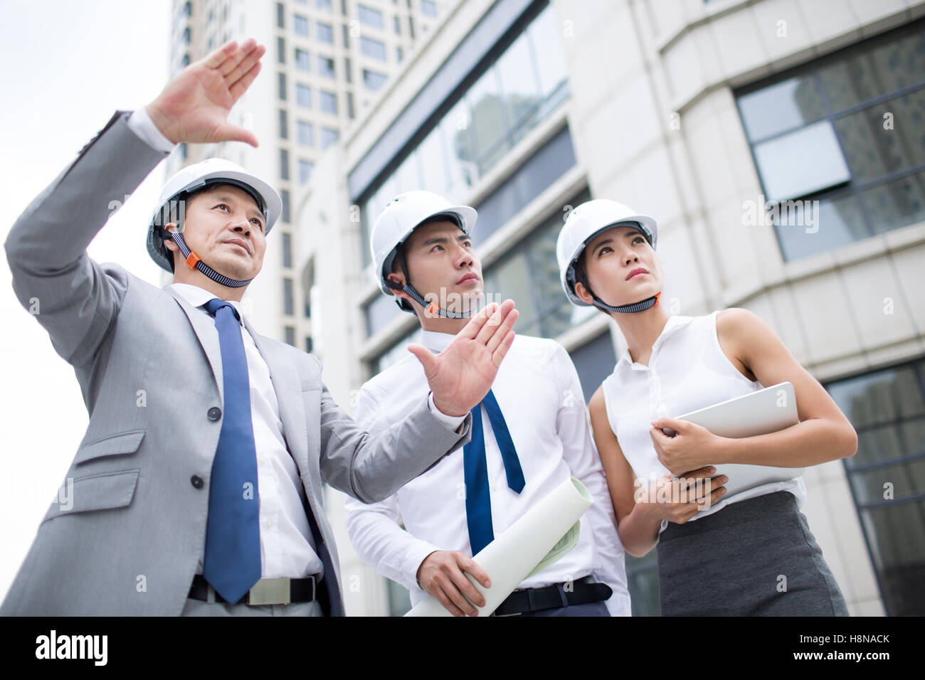 Confident Chinese architects talking outdoors Stock Photo - Alamy