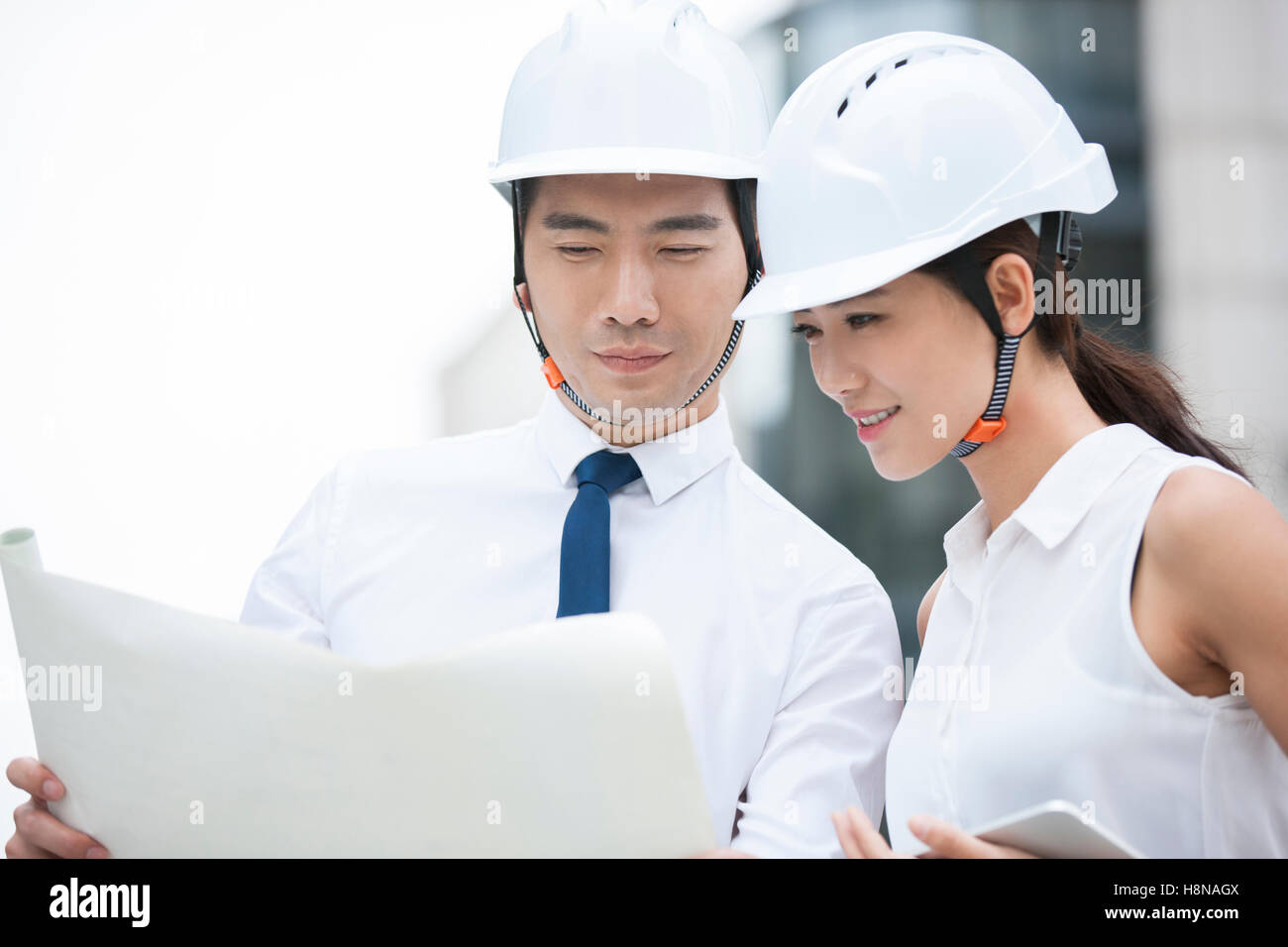 Confident Chinese architects talking outdoors Stock Photo - Alamy