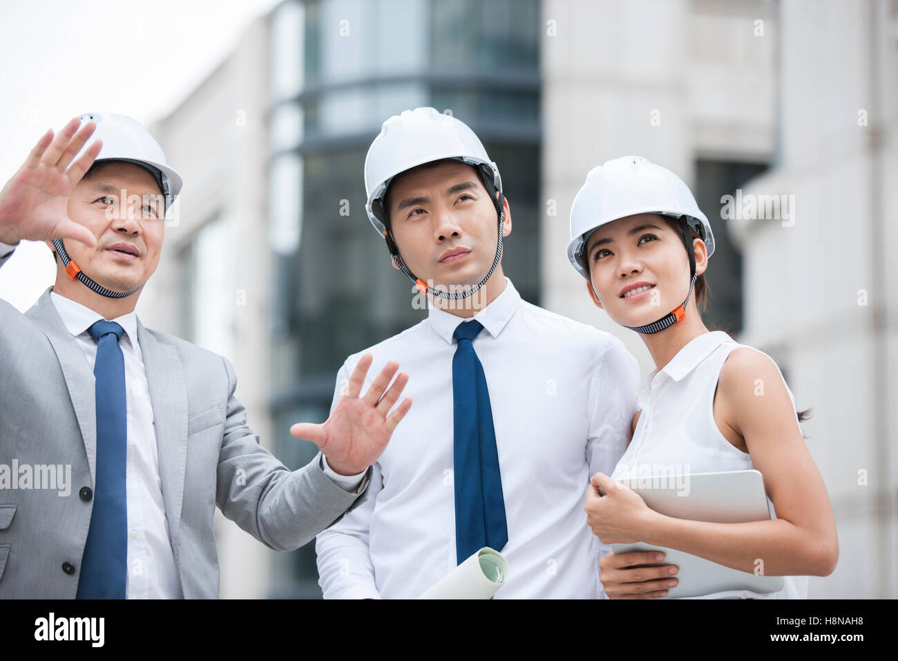 Confident Chinese architects talking outdoors Stock Photo - Alamy