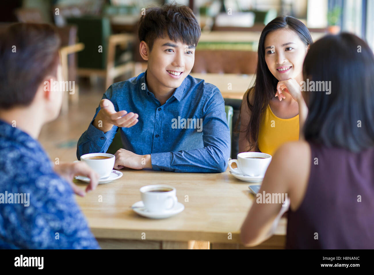 Young Chinese friends talking in cafe Stock Photo - Alamy
