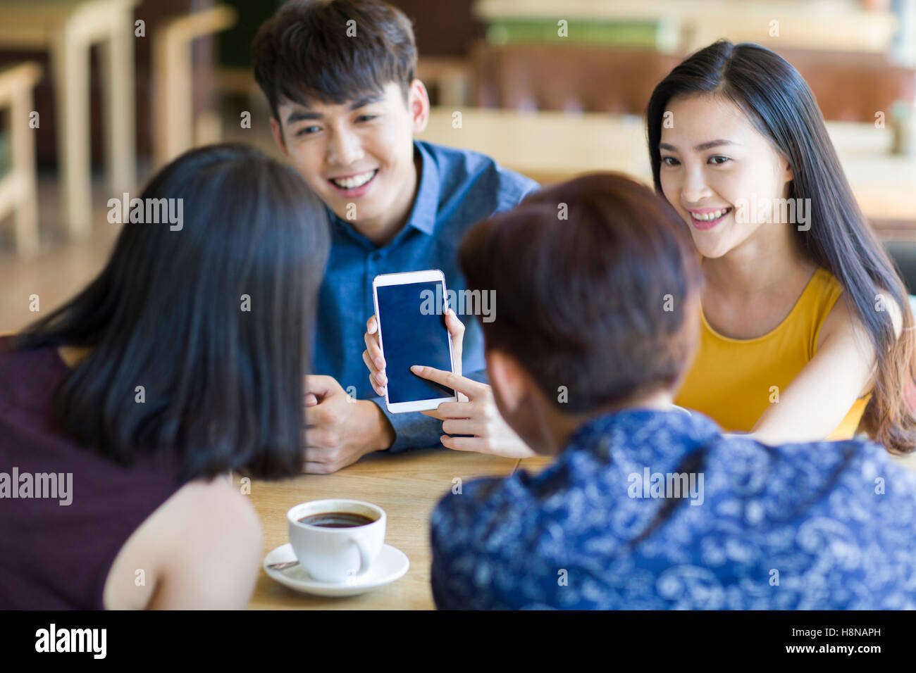 Young Chinese friends talking in cafe Stock Photo - Alamy