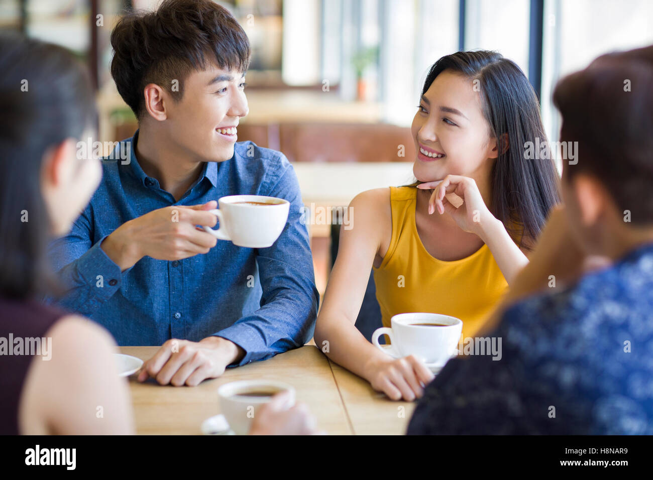 Young Chinese friends talking in cafe Stock Photo - Alamy