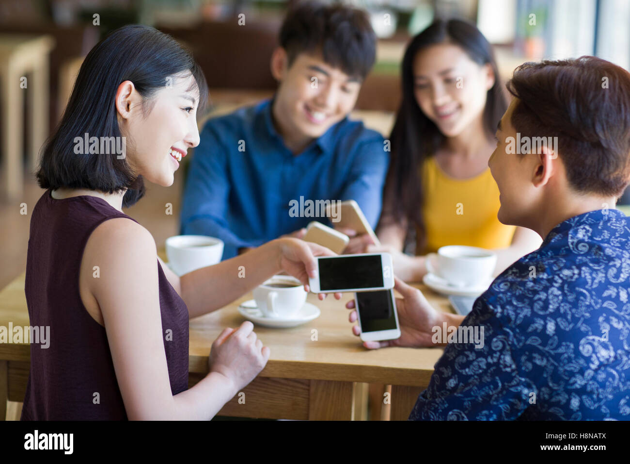 Young Chinese friends using smart phones in cafe Stock Photo - Alamy