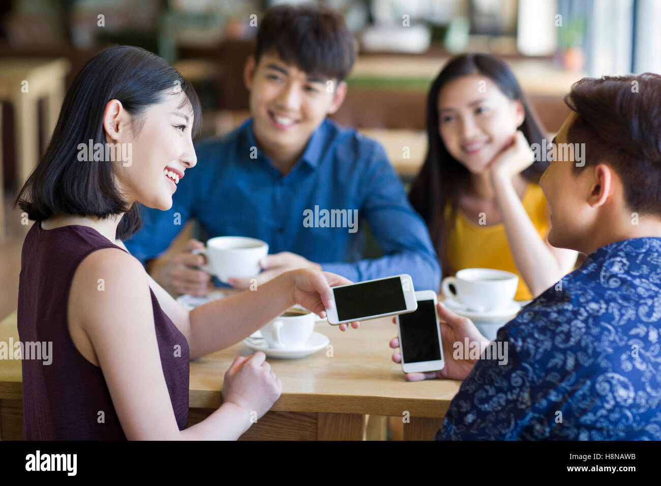 Young Chinese friends using smart phones in cafe Stock Photo - Alamy