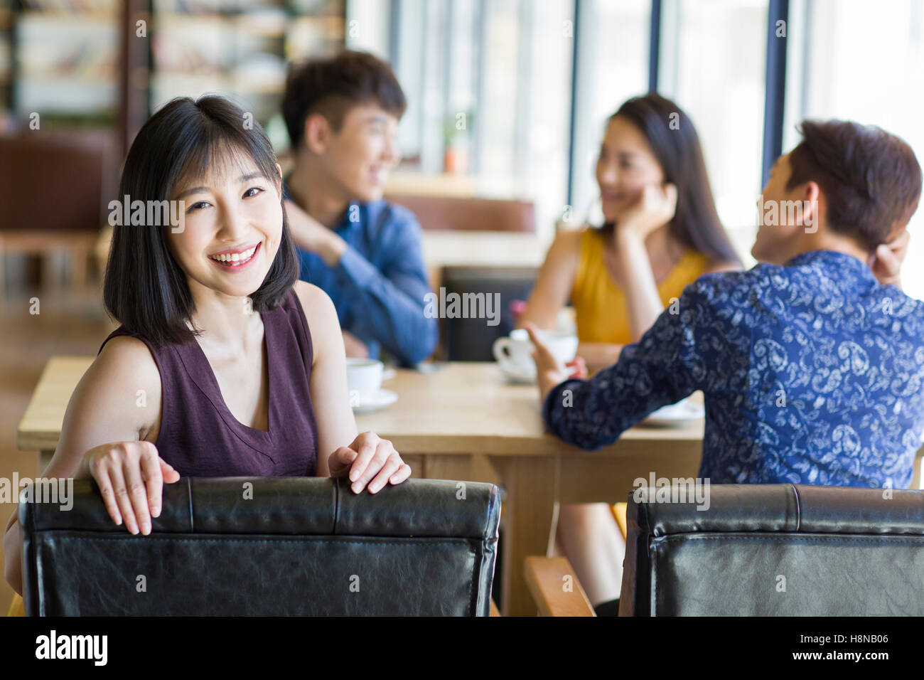 Young Chinese woman drinking coffee with friends in cafe Stock Photo ...