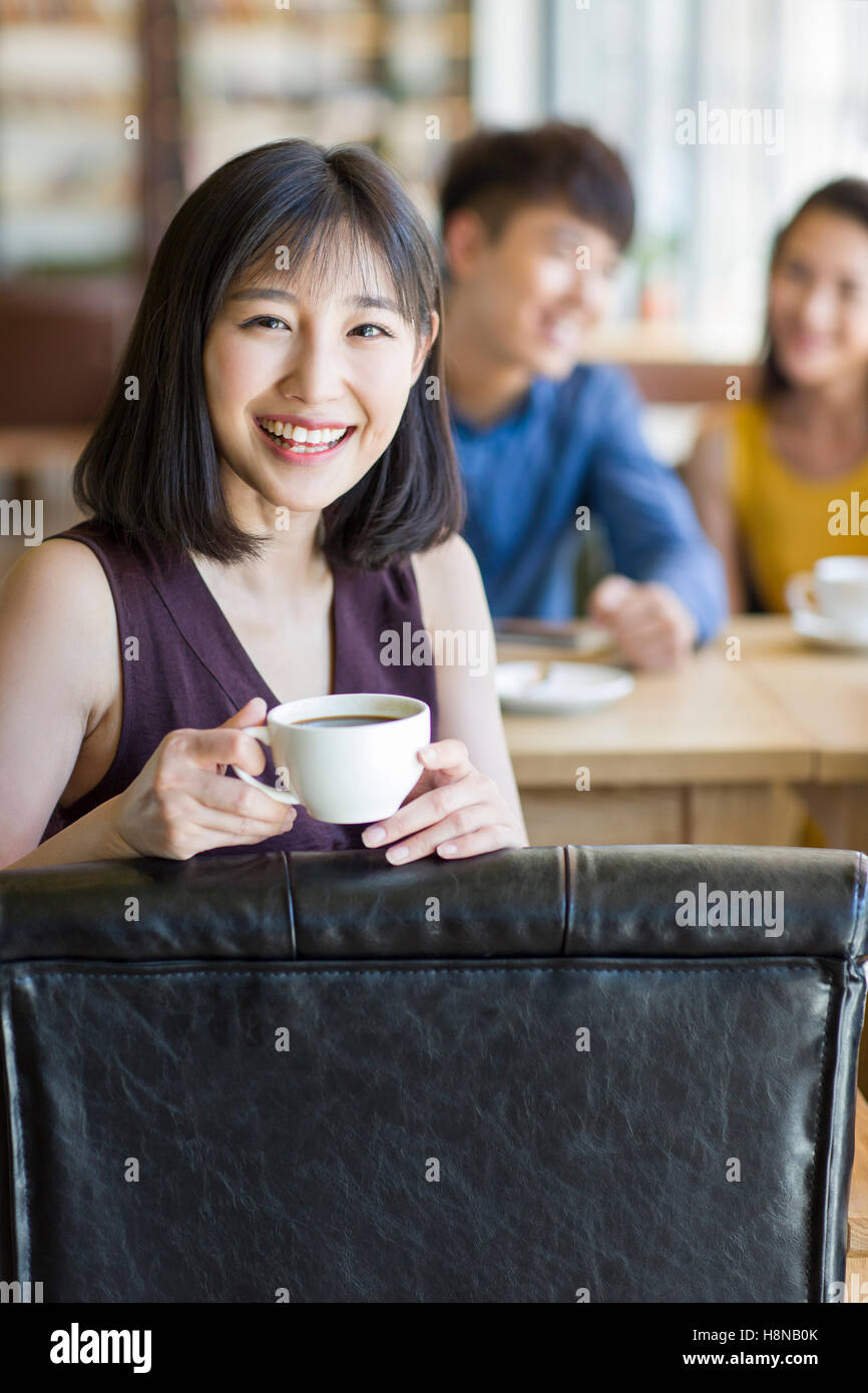 Young Chinese woman drinking coffee with friends in cafe Stock Photo ...
