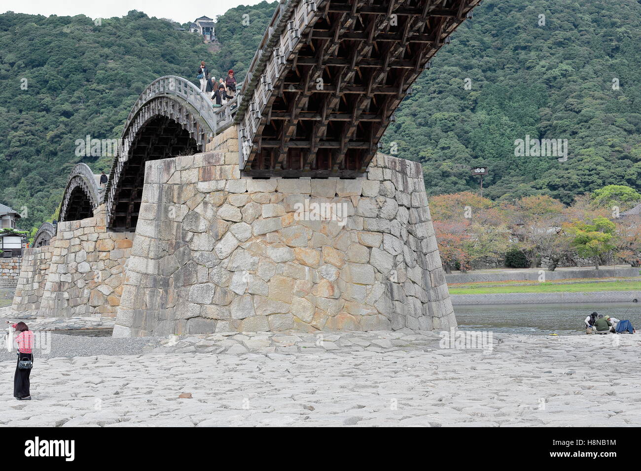 IWAKUNI, JAPAN-OCTOBER 18: Locals and tourists cross Kintai Kyo-bridge ...
