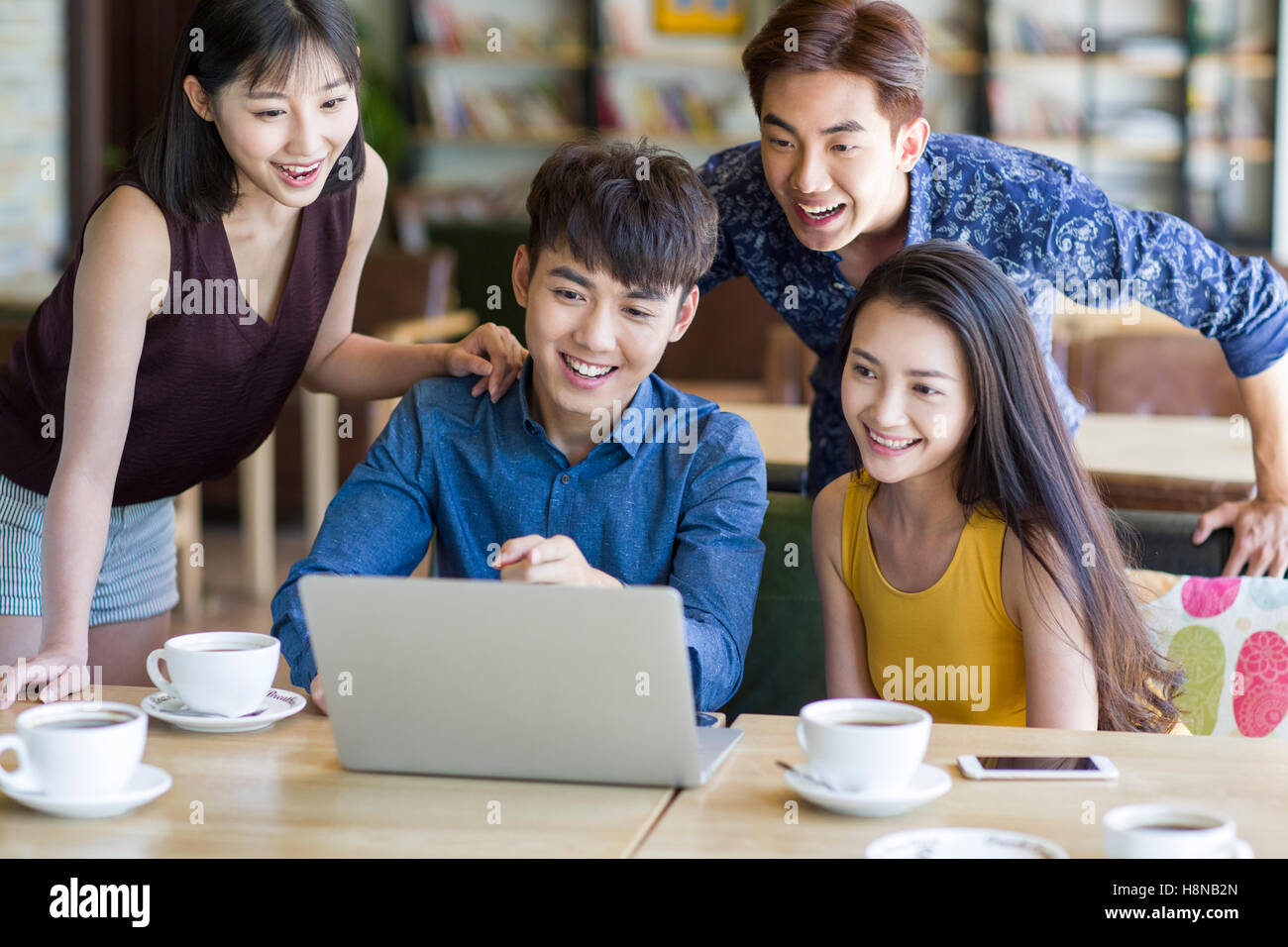 Young Chinese friends using laptop in cafe Stock Photo - Alamy