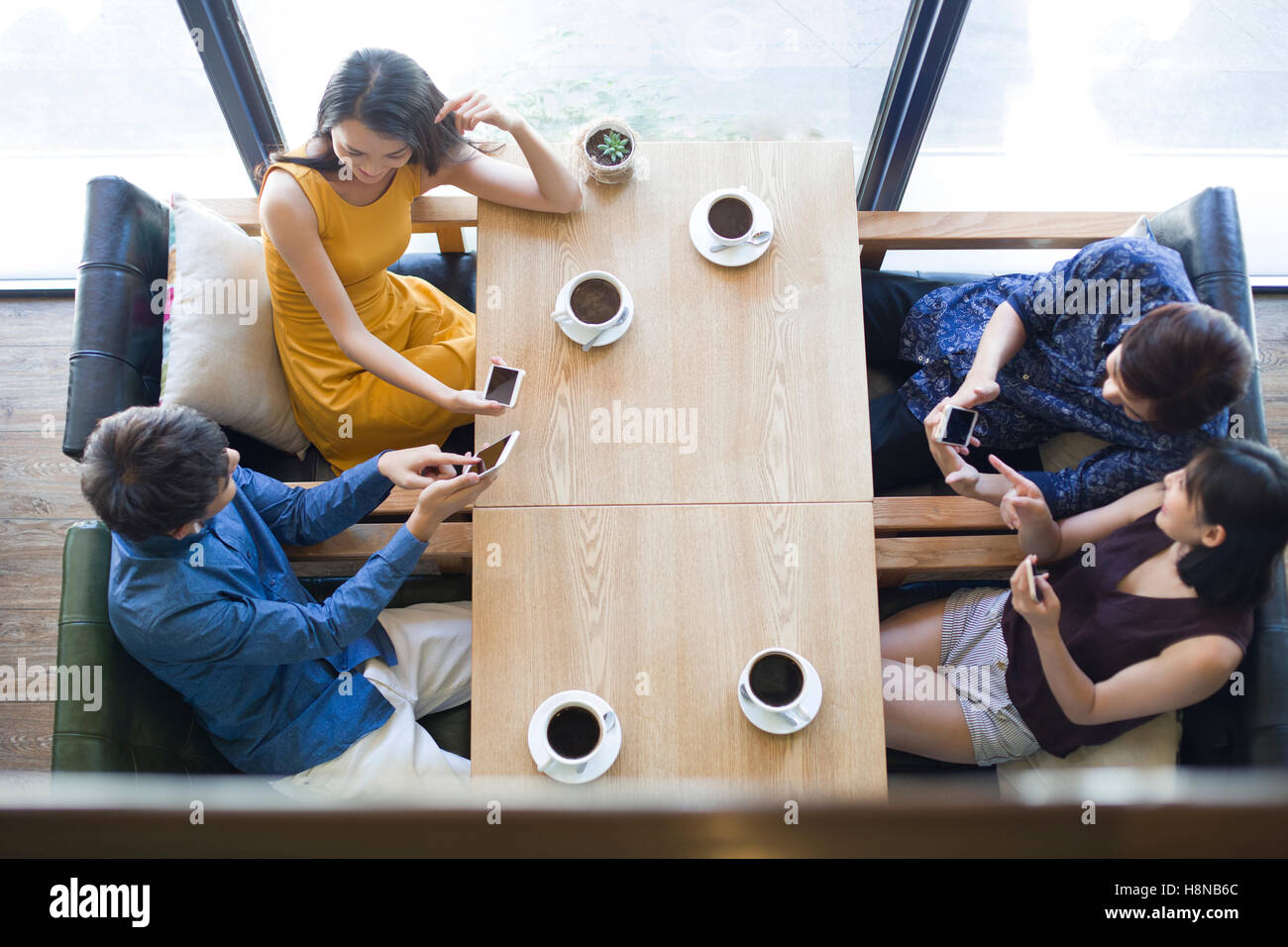 Young Chinese friends using smart phones in cafe Stock Photo - Alamy