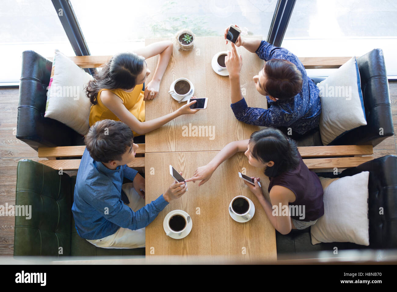 Young Chinese friends using smart phones in cafe Stock Photo - Alamy