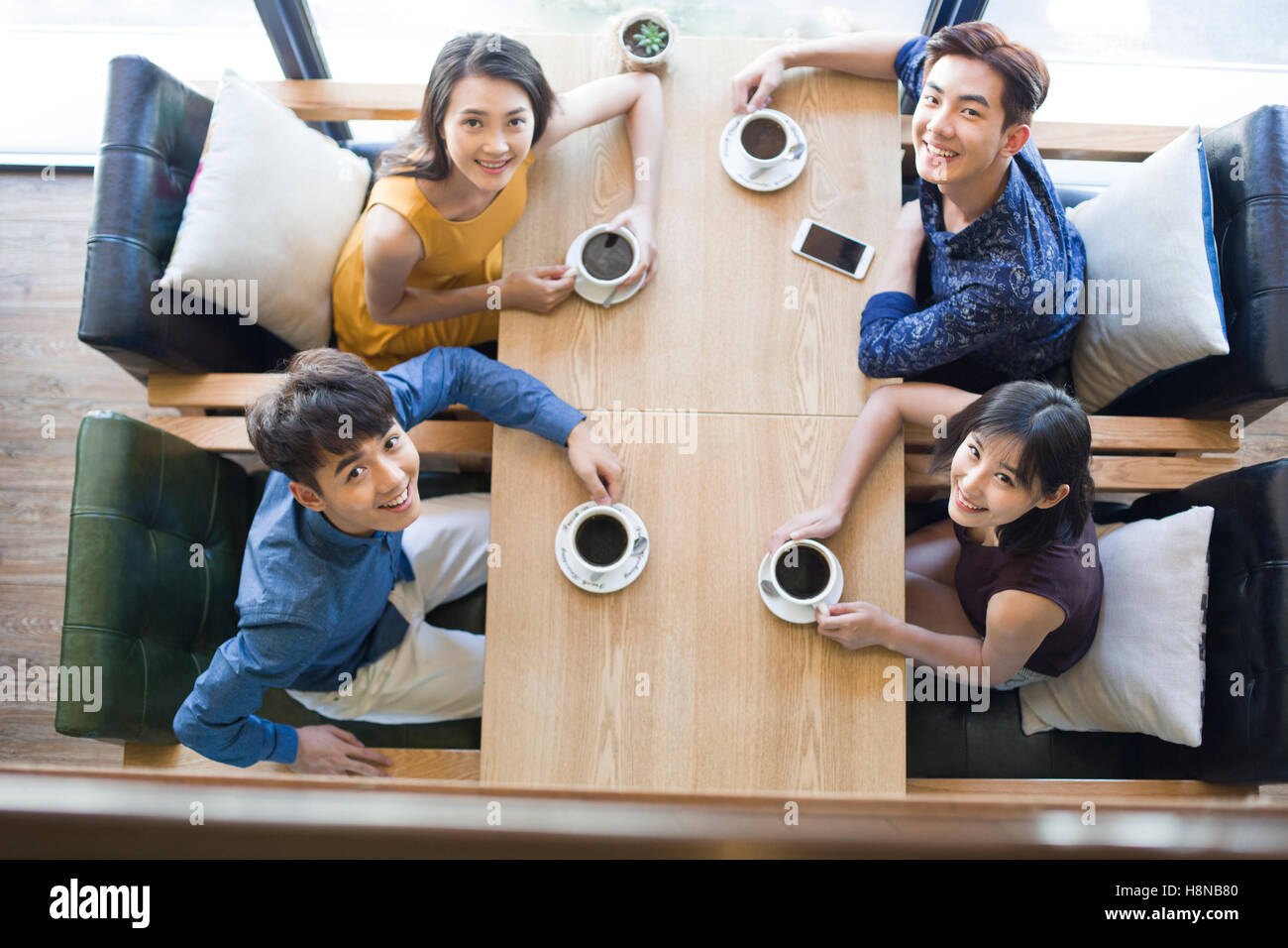 Young Chinese friends drinking coffee in cafe Stock Photo - Alamy
