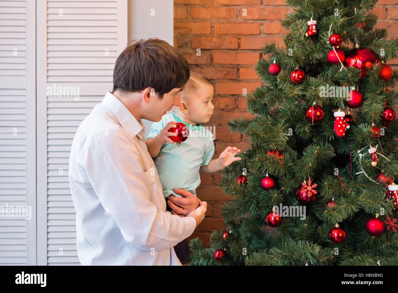 Father and son are decorating the Christmas tree Stock Photo - Alamy