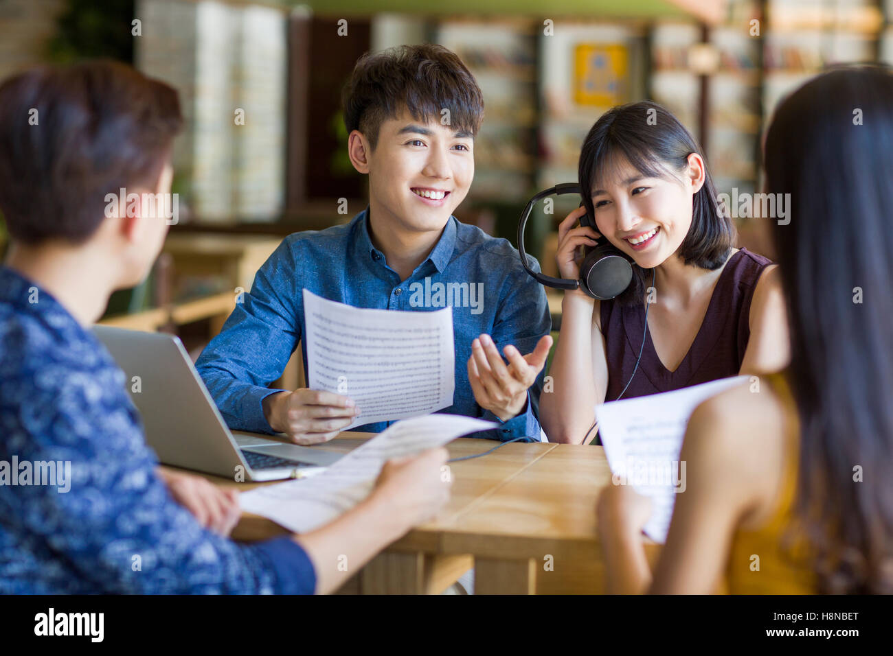 Young Chinese friends talking about music in cafe Stock Photo - Alamy