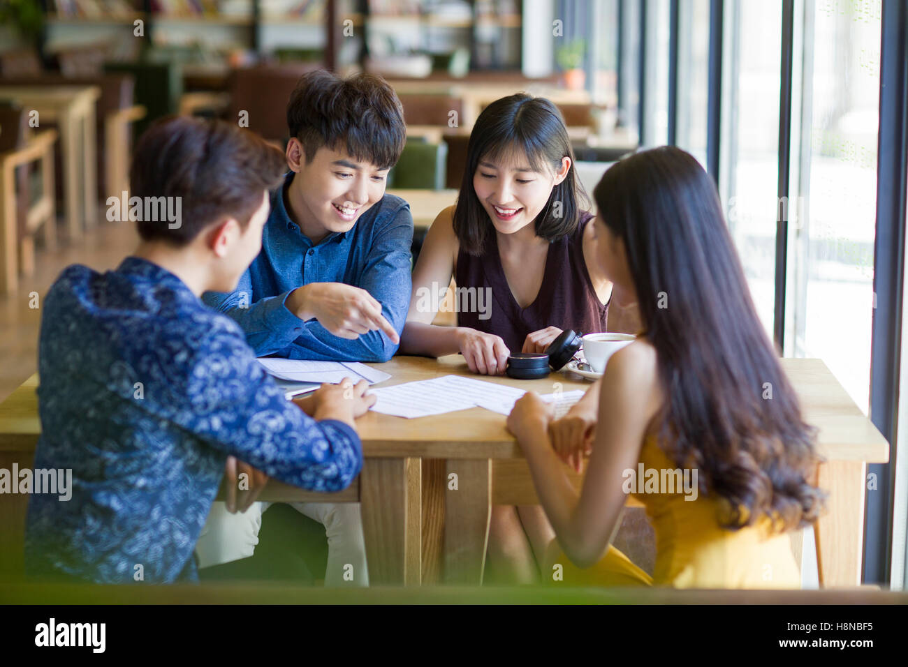 Young Chinese friends talking about music in cafe Stock Photo - Alamy
