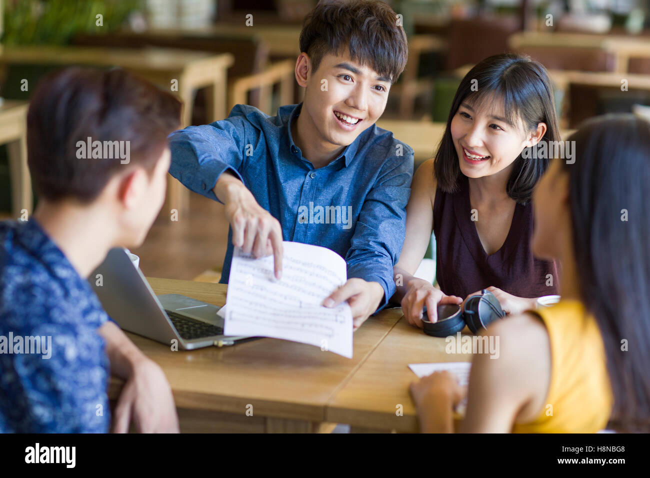 Young Chinese friends talking about music in cafe Stock Photo - Alamy