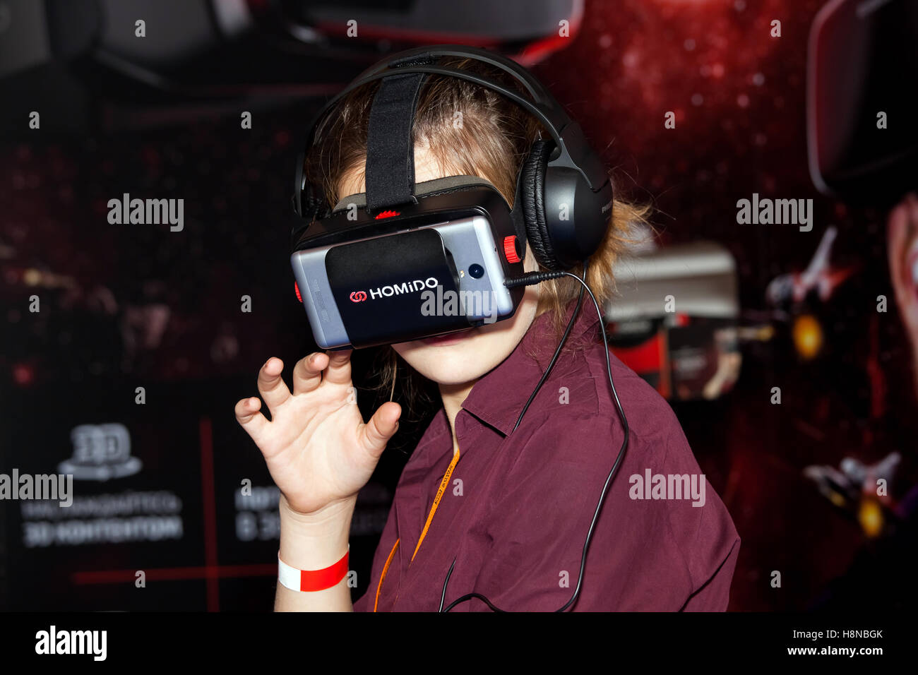 Girl playing with Homido virtual reality headset on Robotics Expo in ...