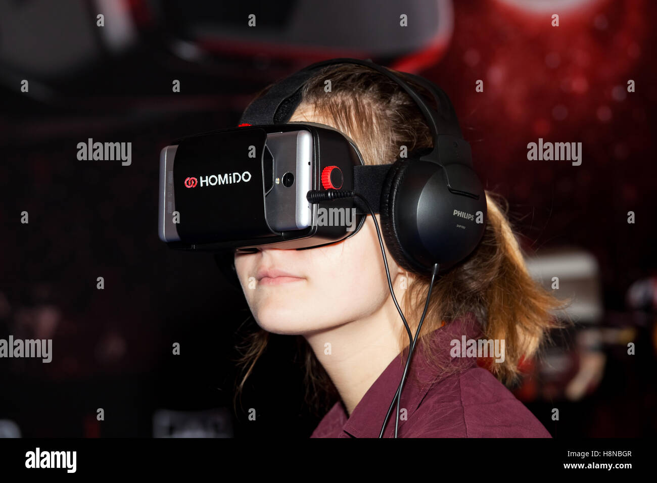 Girl playing with Homido virtual reality headset on Robotics Expo in ...