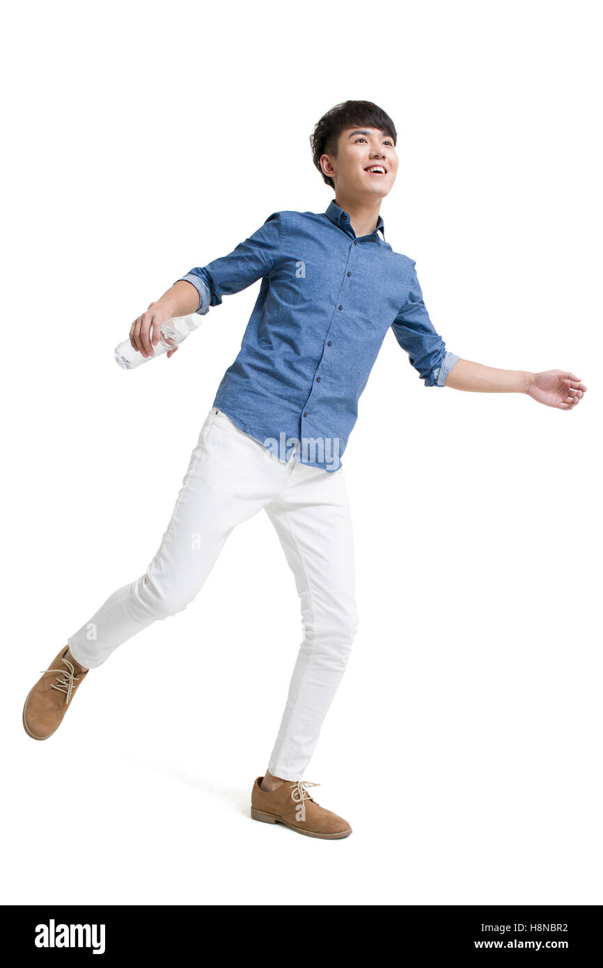 Happy young Chinese man running with a bottle of water Stock Photo - Alamy