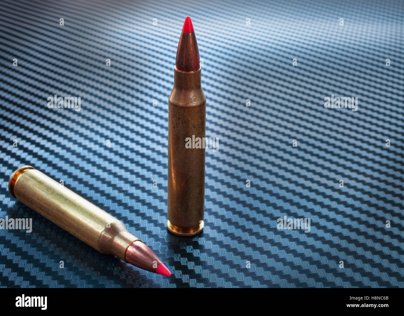 Two rounds that are loaded with polymer tipped bullets on a graphite ...