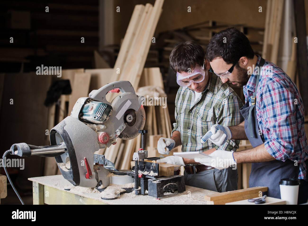 Two men builder with circular saw having a conversation Stock Photo - Alamy
