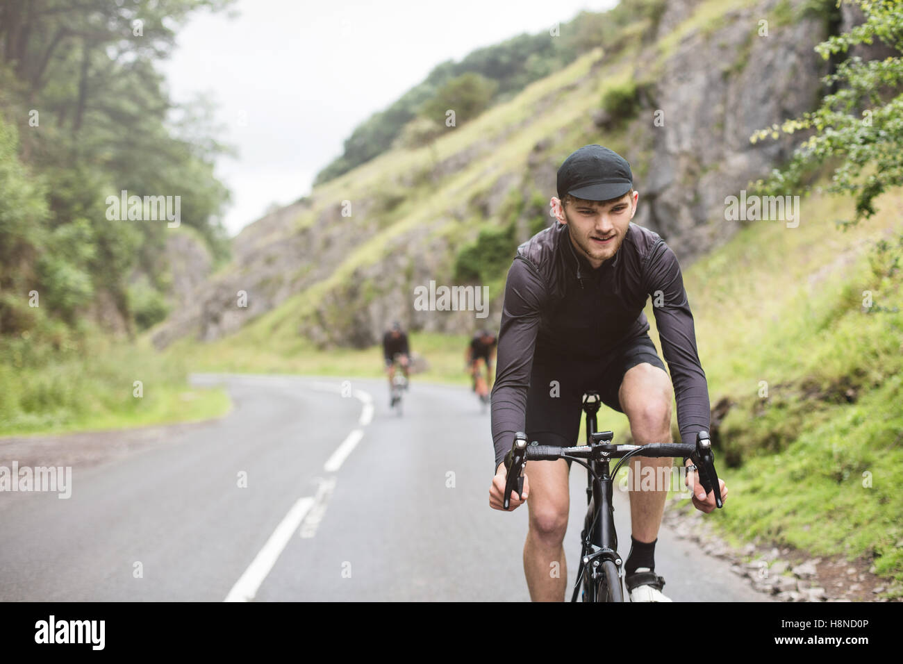 A young cyclist is in the lead during a fun road race with friends ...