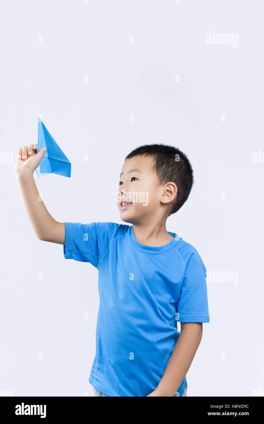Happy little Chinese boy throwing a paper airplane Stock Photo - Alamy