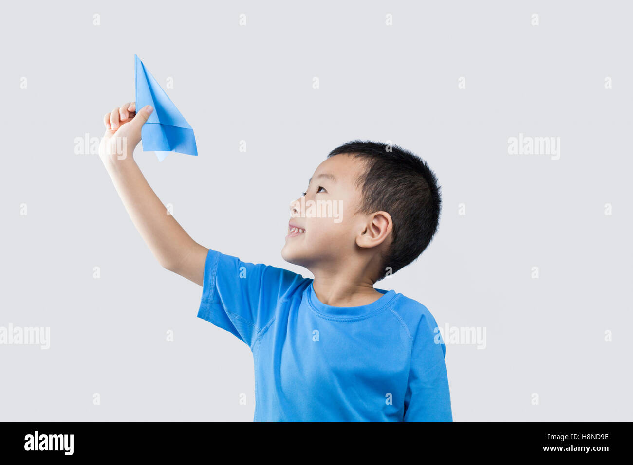 Happy little Chinese boy throwing a paper airplane Stock Photo - Alamy