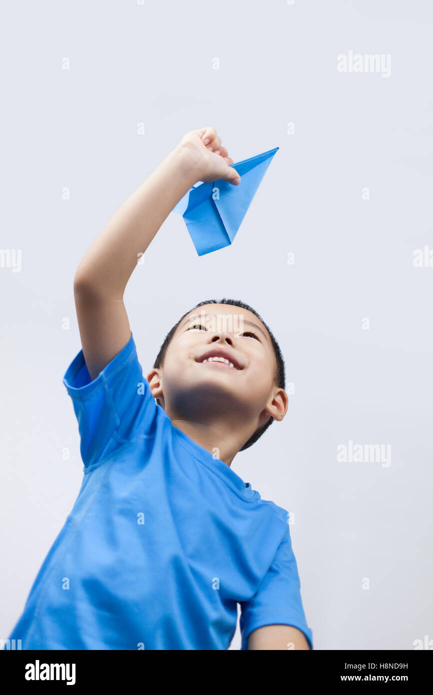 Happy little Chinese boy throwing a paper airplane Stock Photo - Alamy