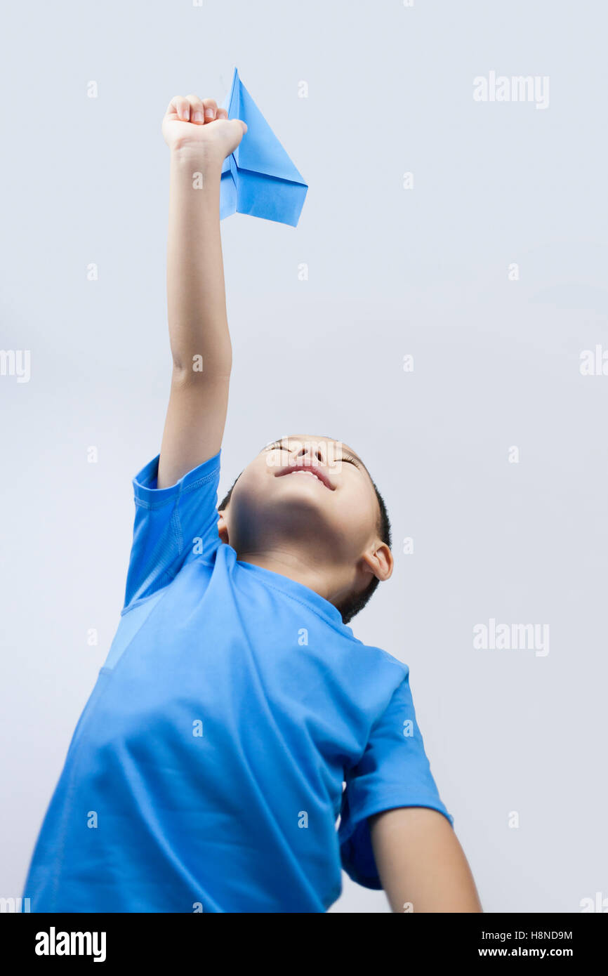 Happy little Chinese boy throwing a paper airplane Stock Photo - Alamy