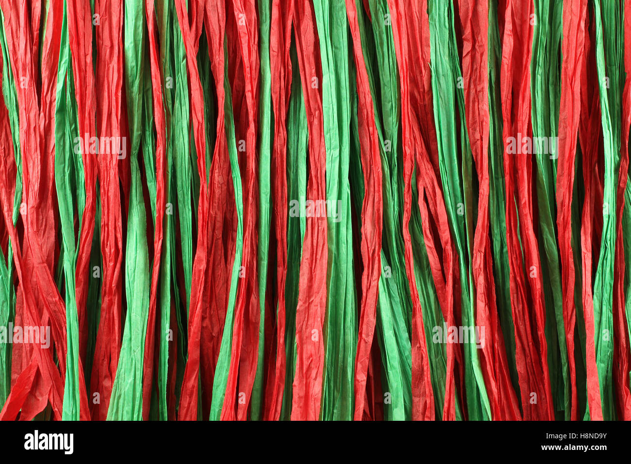 Background - red and green paper raffia strips situated in parallel ...