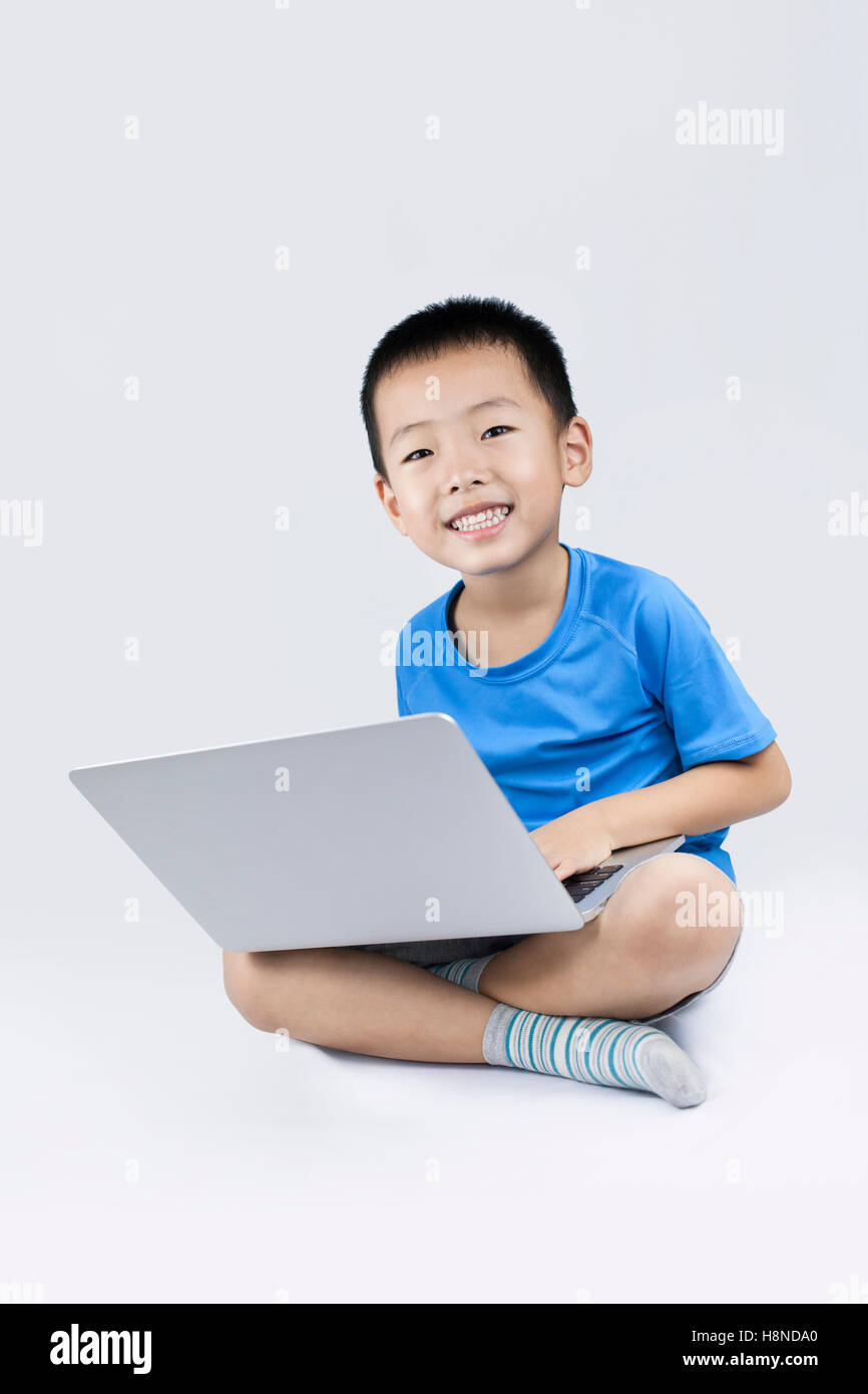 Happy little Chinese boy using a laptop Stock Photo - Alamy