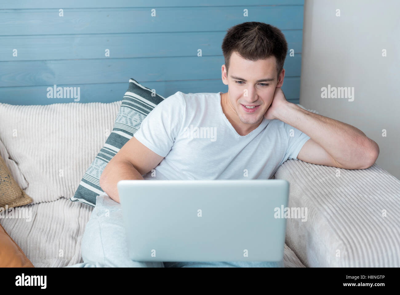 Involved young man using laptop Stock Photo - Alamy
