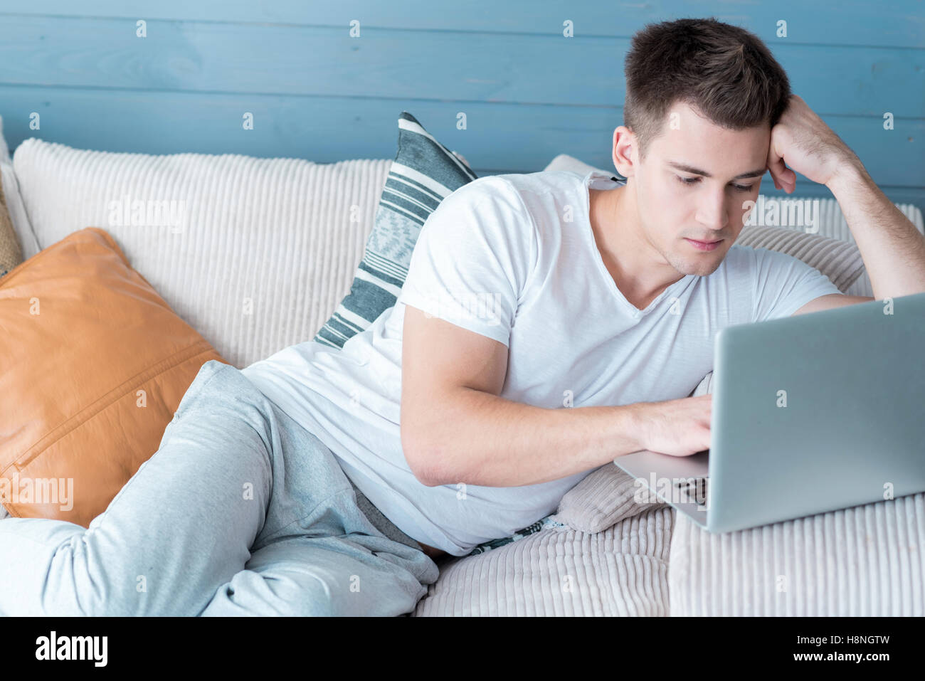 Concentrated young man using laptop Stock Photo - Alamy