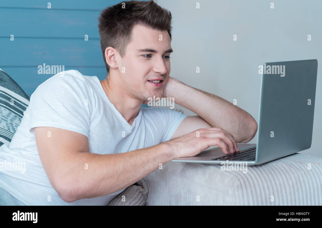 Handsome young man working on laptop Stock Photo - Alamy