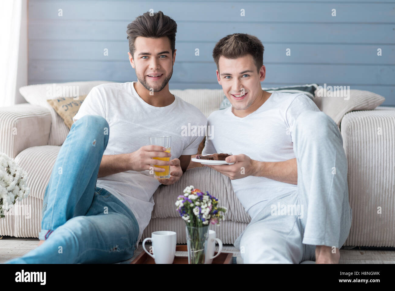 Male partners having food together Stock Photo - Alamy