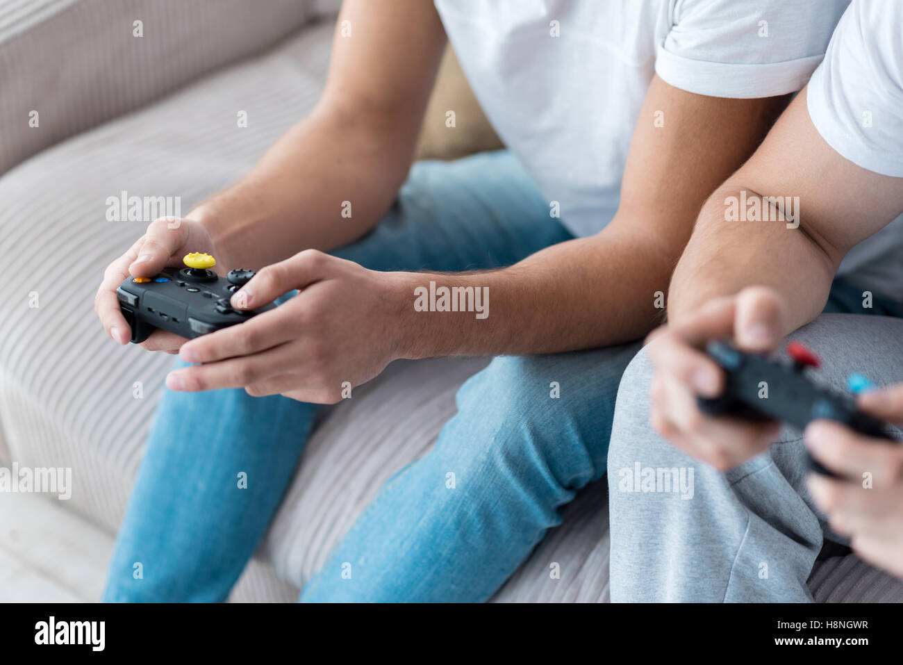 Male friends playing console games Stock Photo - Alamy