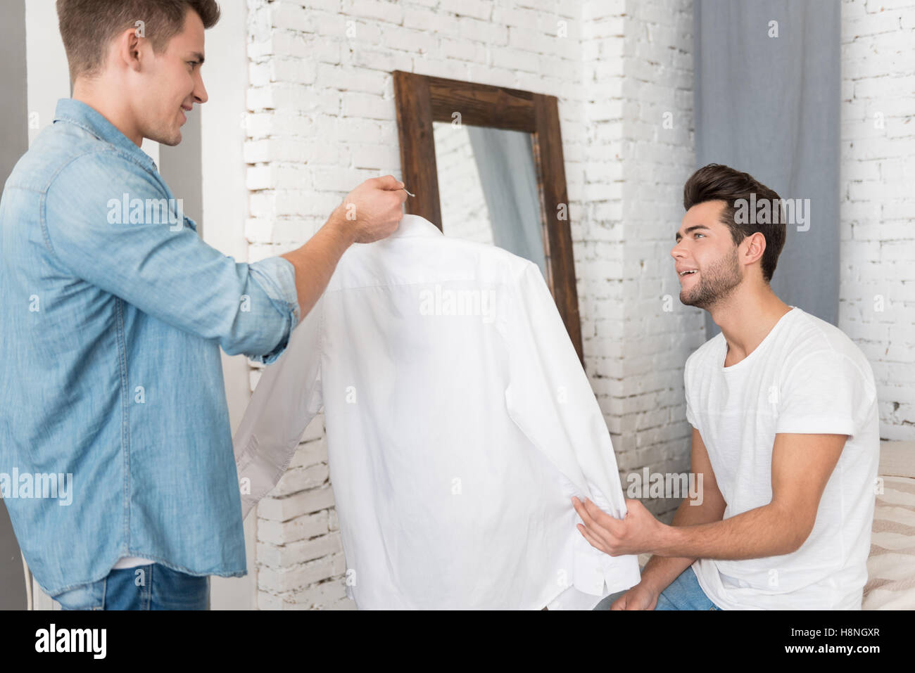 Handsome young man giving a shirt to his boyfriend Stock Photo - Alamy