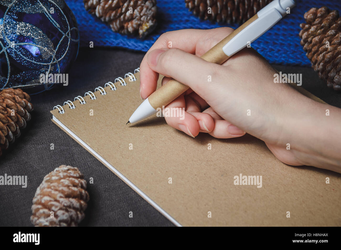 female hand, pen, notebook, on the christmas decorations background ...
