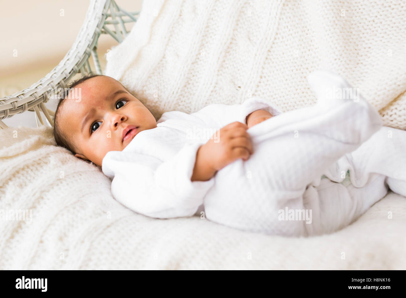 Thoughtful biracial mix of Hispanic and African American infant lying ...
