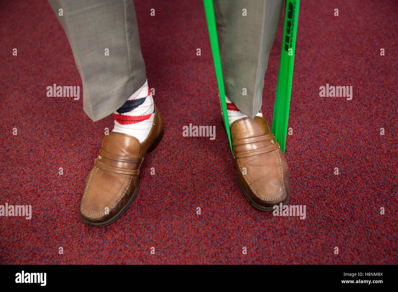 Elderly person in sitting down exercise class using resistance band ...