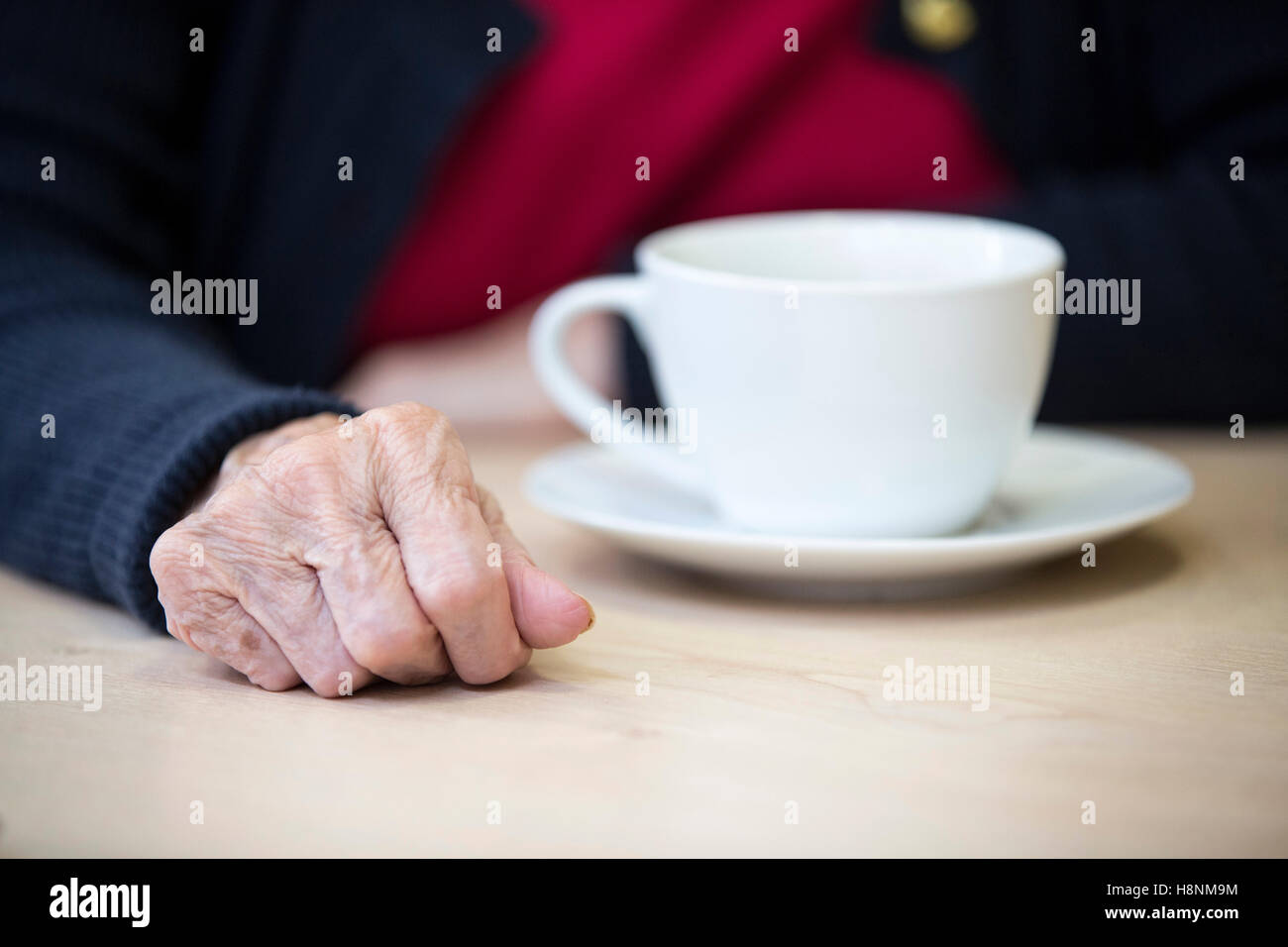 Elderly person sitting down with cup of tea at drop-in centre Stock ...
