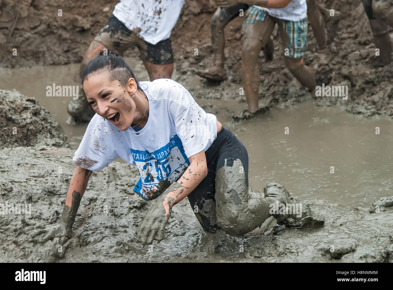 Attractive girl in extrime racing in mud hole Stock Photo - Alamy
