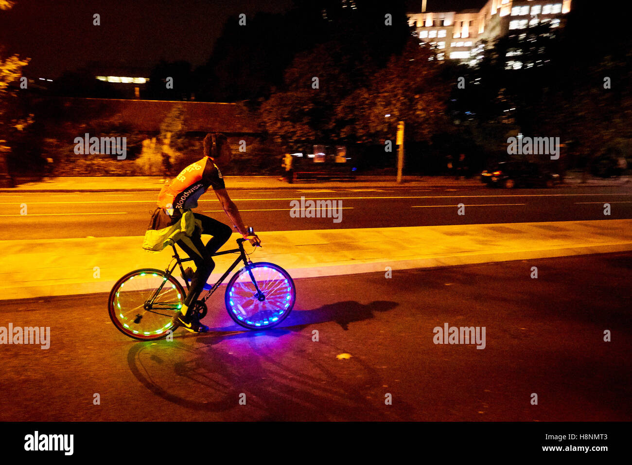 A cyclist at night in London with lights on his wheels Stock Photo - Alamy