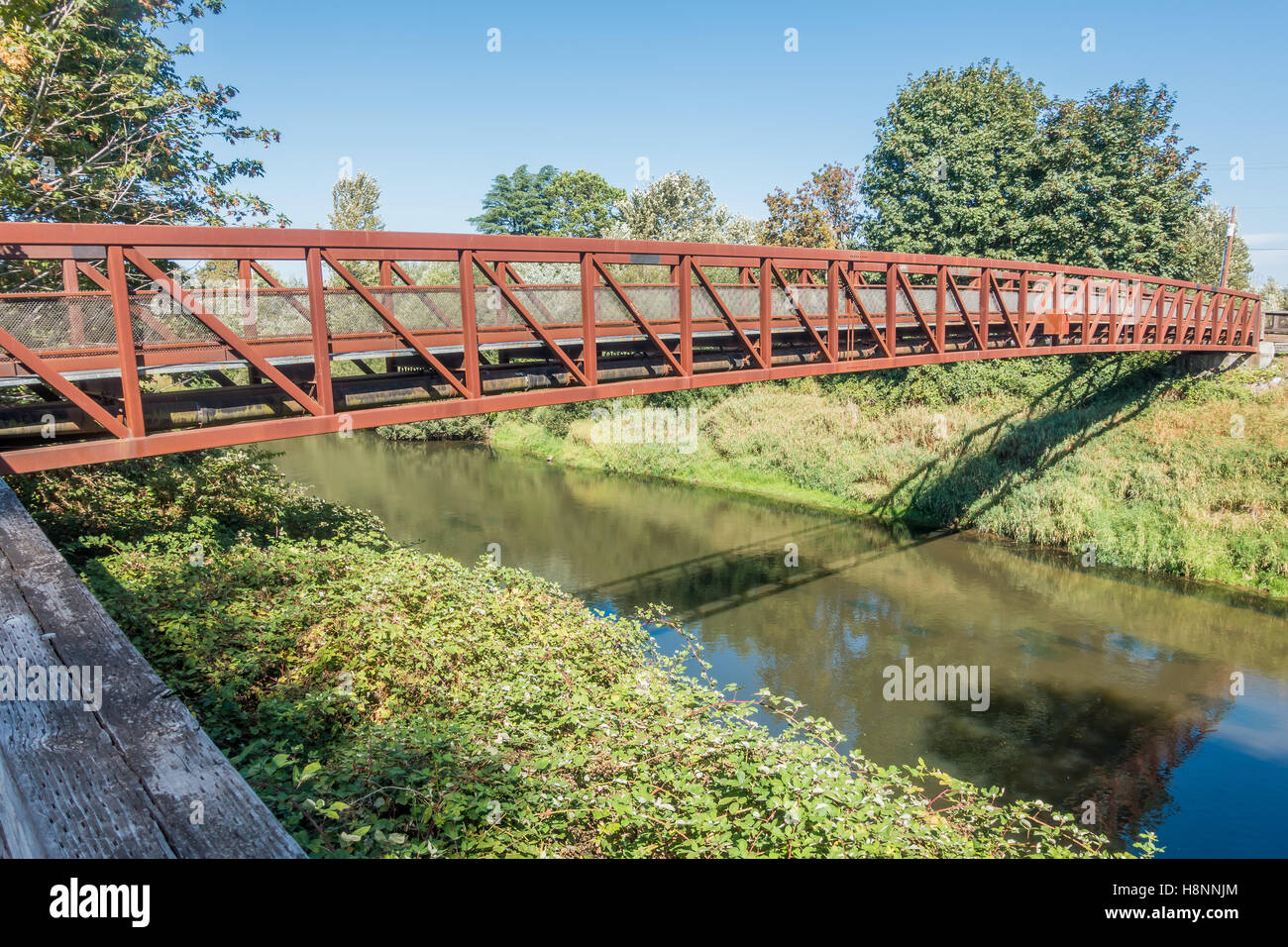 A metal walking bridge spans the Green River in Washington State Stock ...