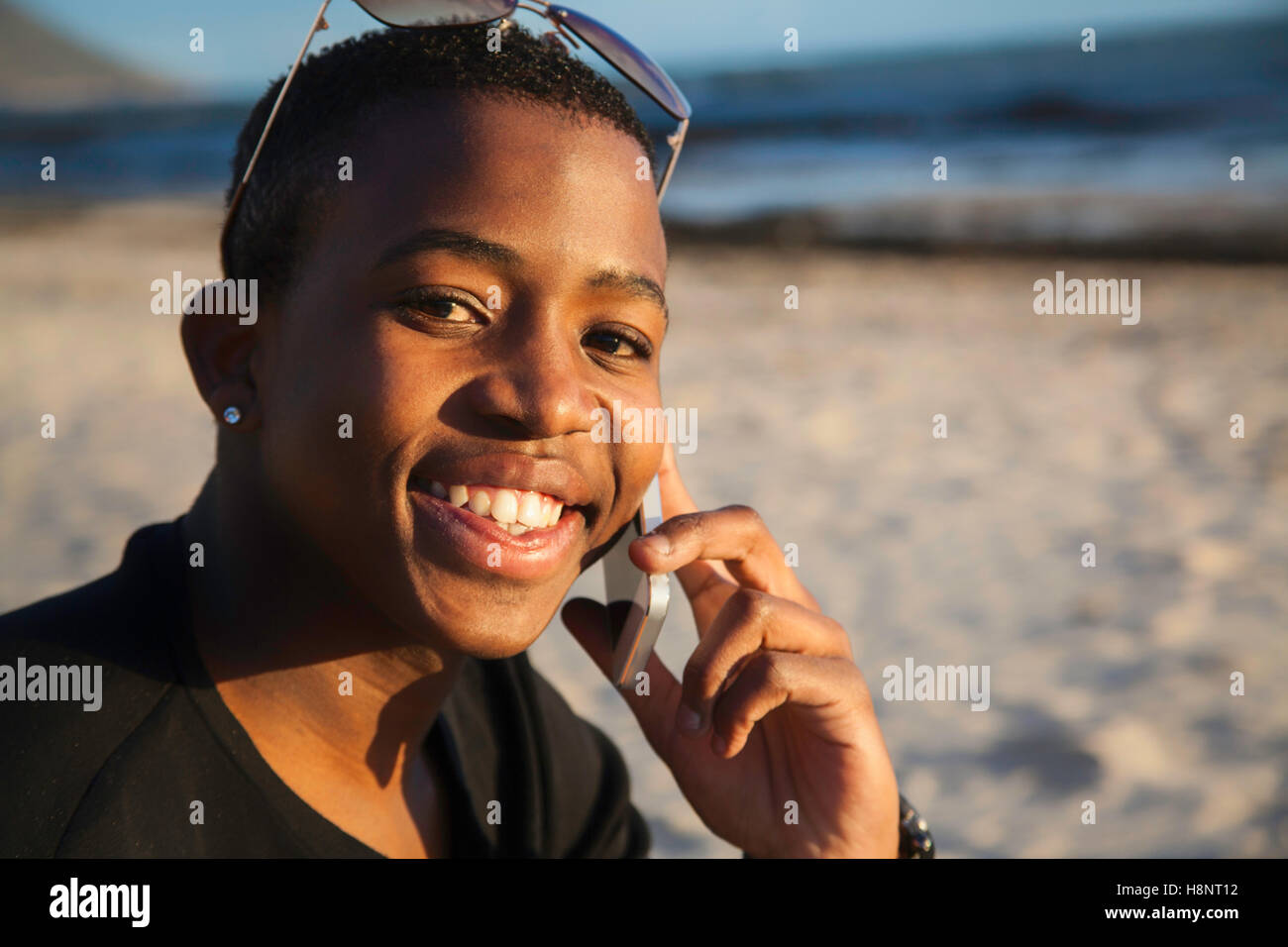 african boy on cell phone sitting outside Stock Photo - Alamy