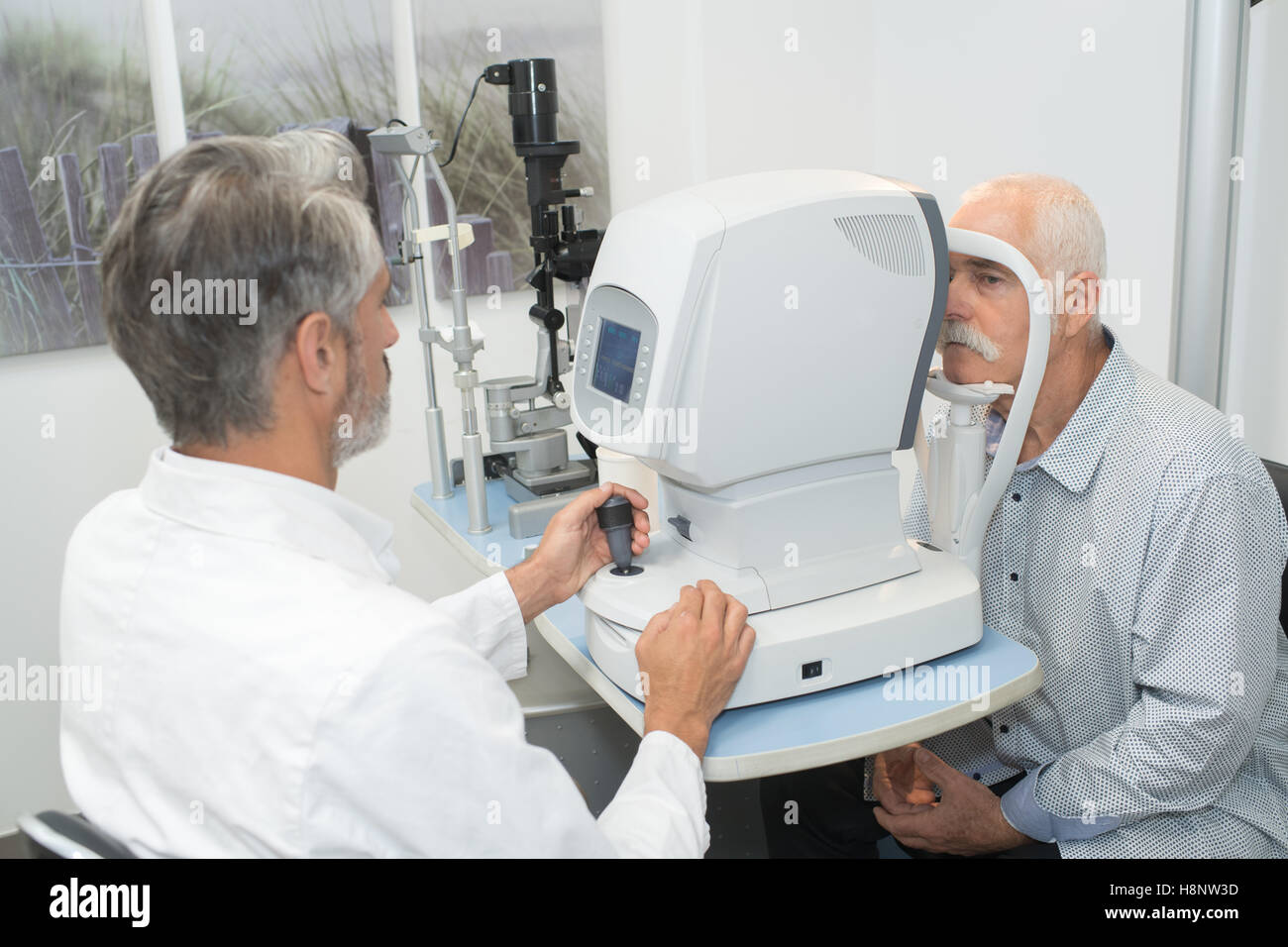 male optometrist doing sight testing for an old patient Stock Photo - Alamy