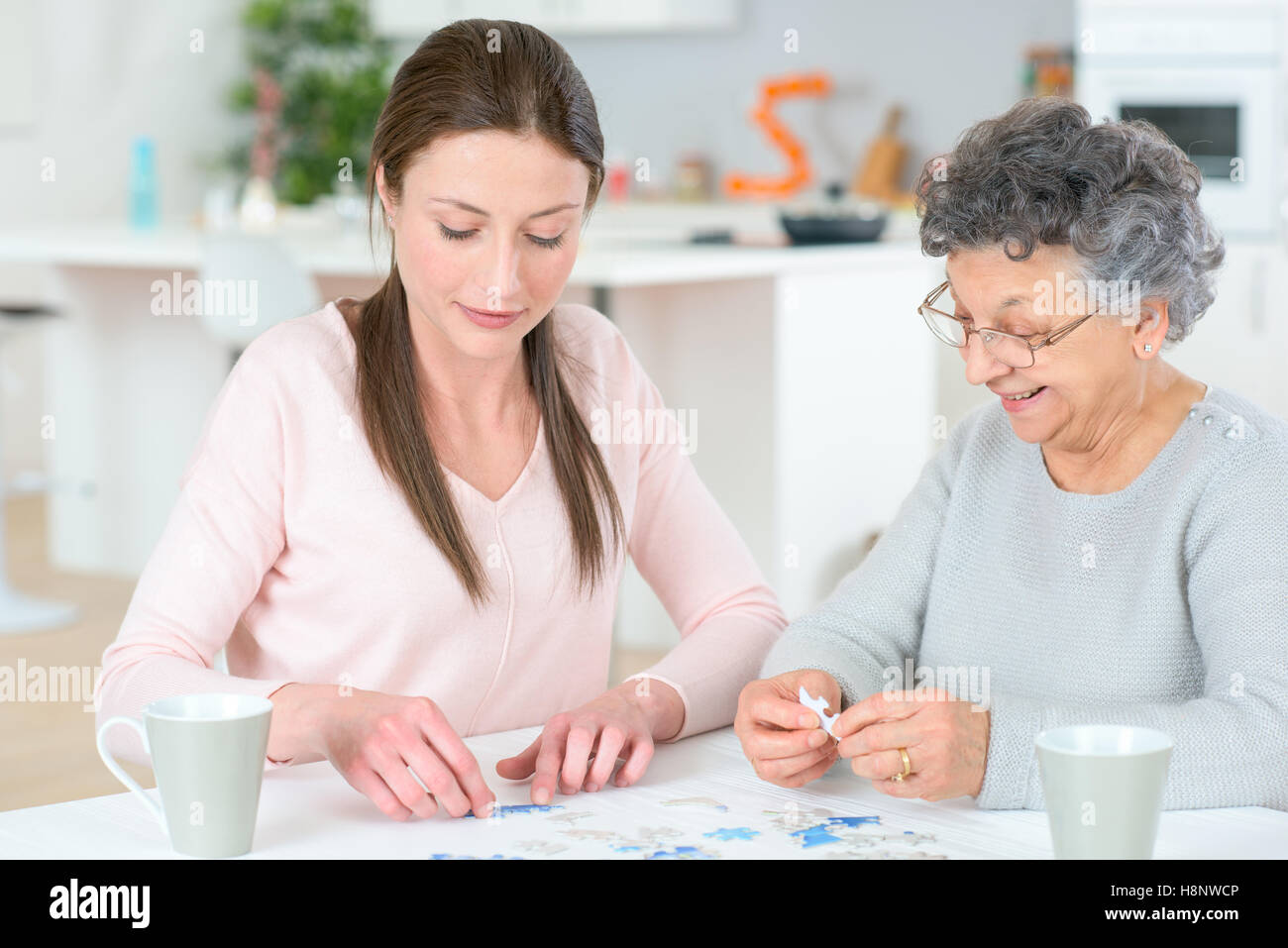 young woman helping senior lady Stock Photo - Alamy