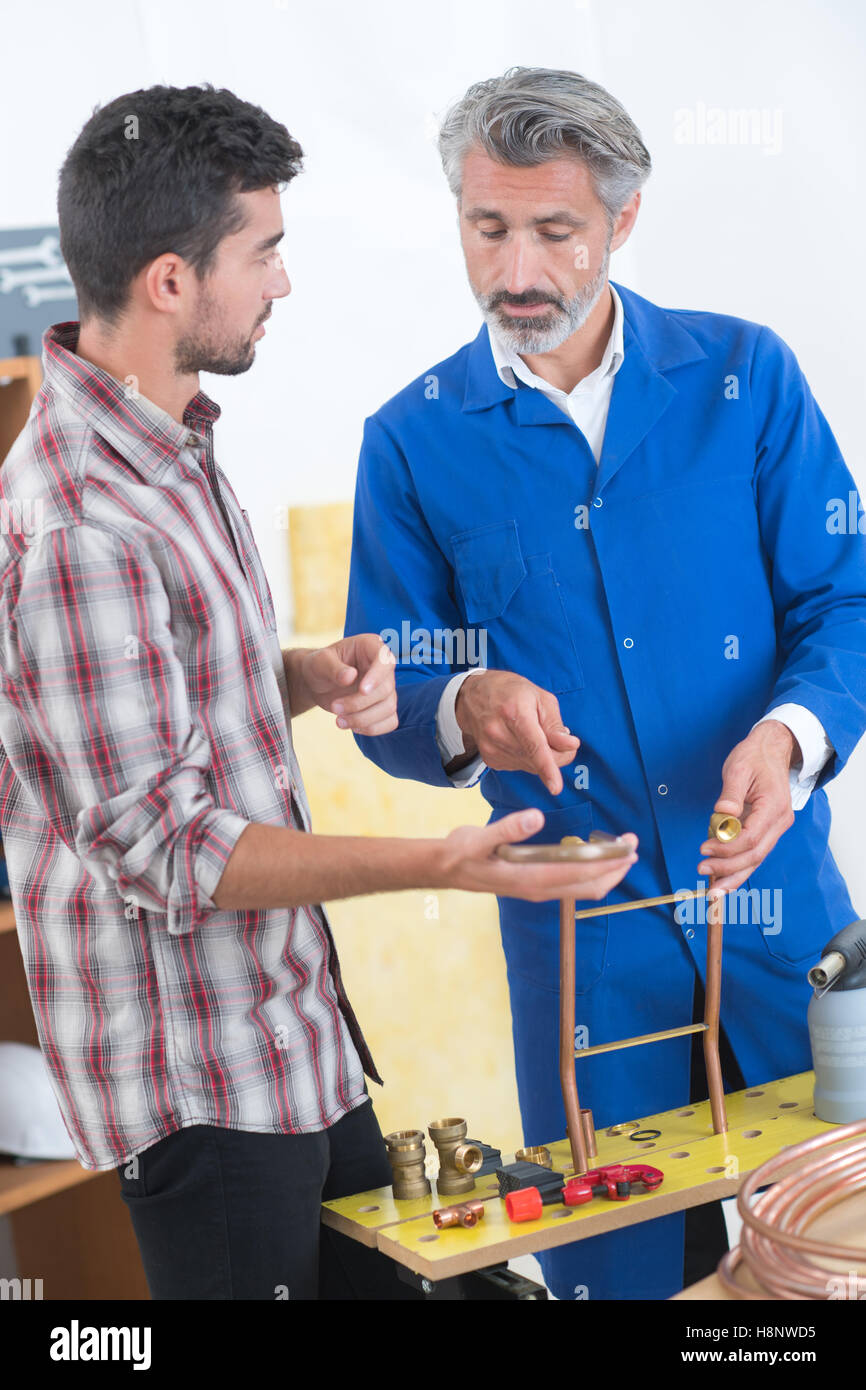 teacher helping college student learning plumbing Stock Photo - Alamy