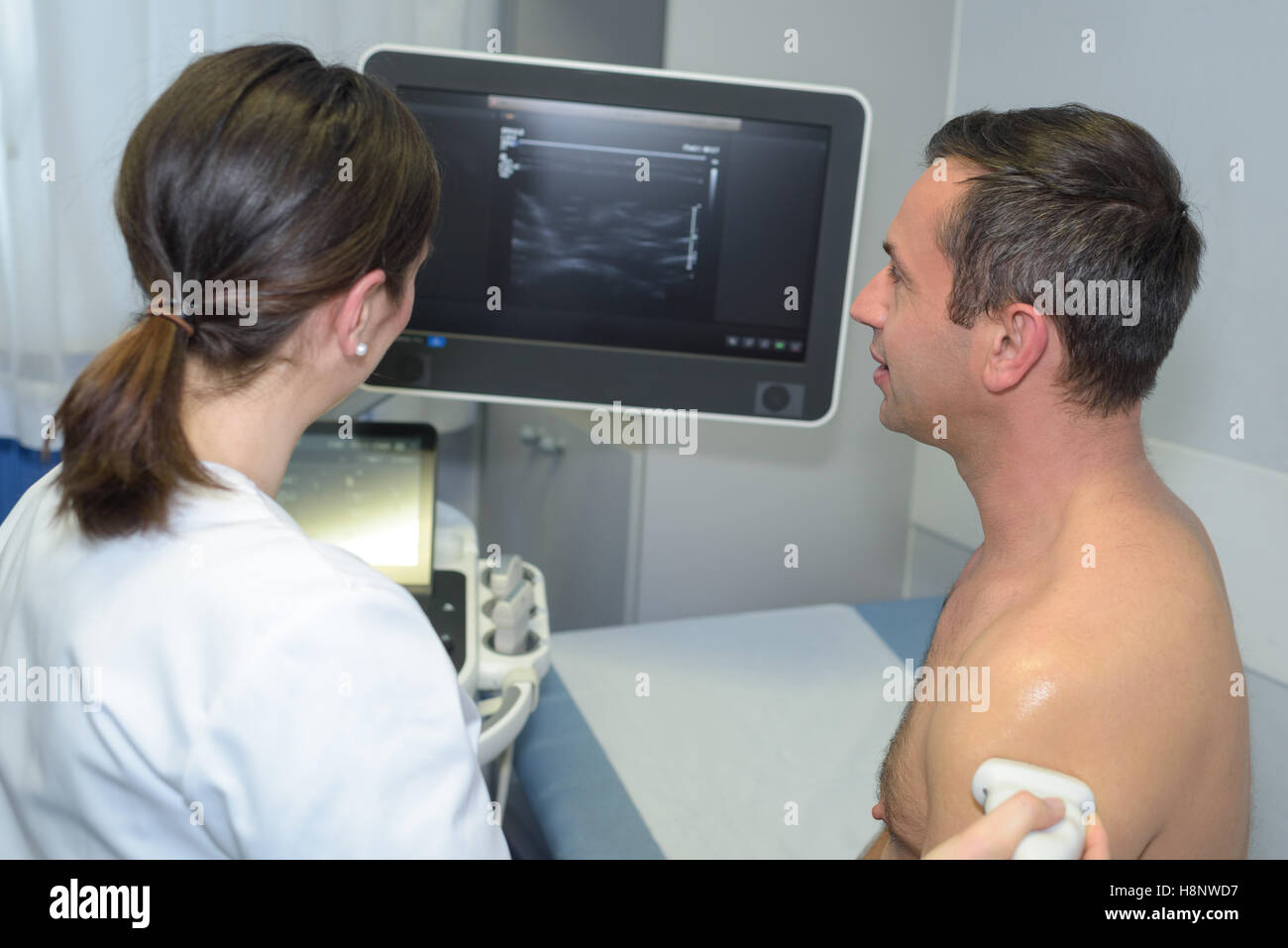 mature man getting ultrasound scan by young female doctor Stock Photo ...