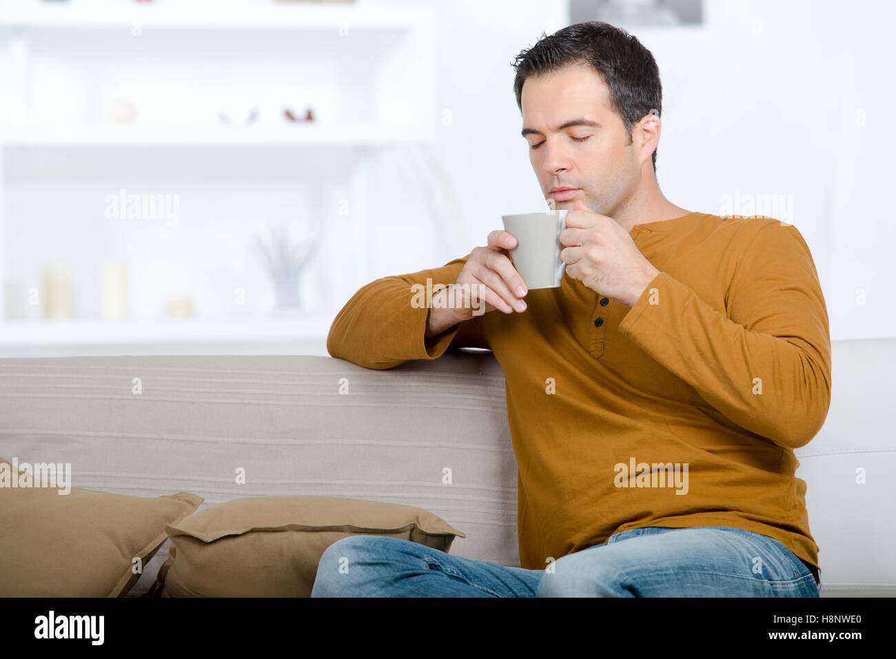 man relaxing on the couch and having a tea Stock Photo - Alamy